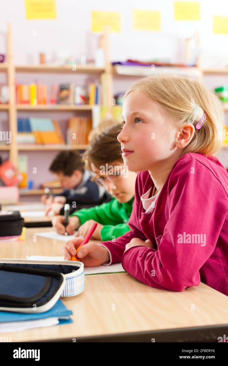 Education - Pupils at primary or elementary school doing their homework ...