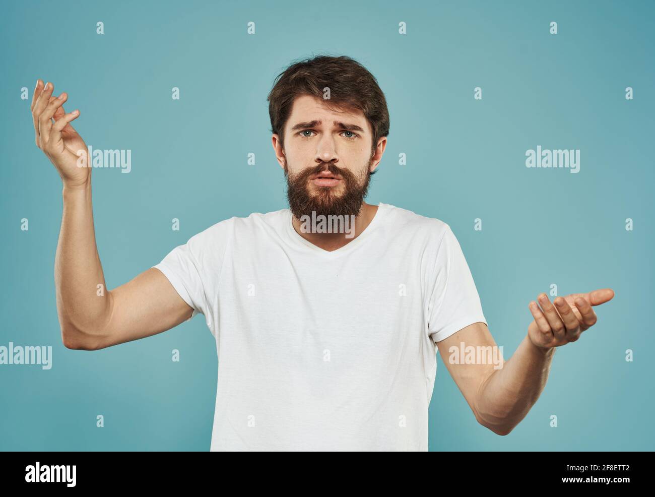 Emotional guy gesturing with his hands on a blue background Copy Space ...
