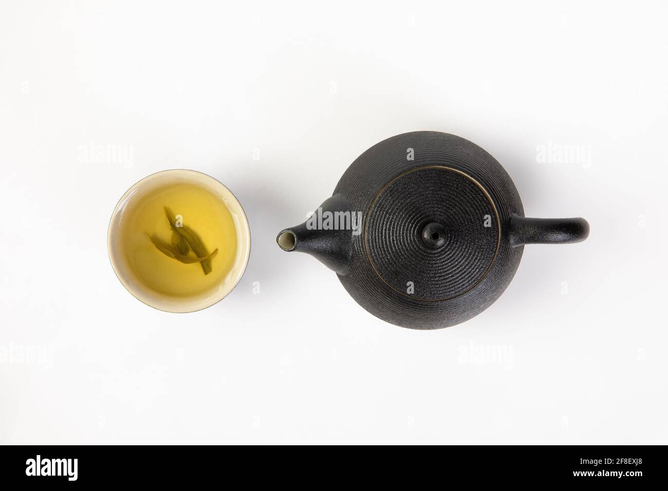 Top view of a black teapot with leaves on teacup isolated on white background Stock Photo - Alamy