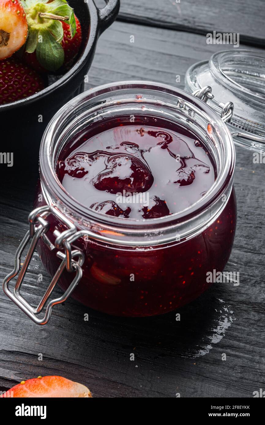 Natural strawberry jam jar, on black wooden table background Stock ...