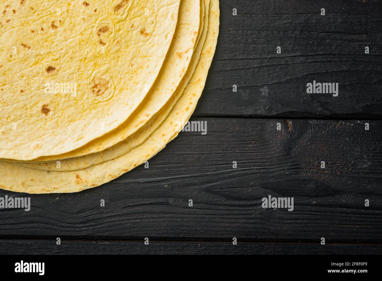 Fresh yellow corn tortilla, on black wooden table background, top view ...