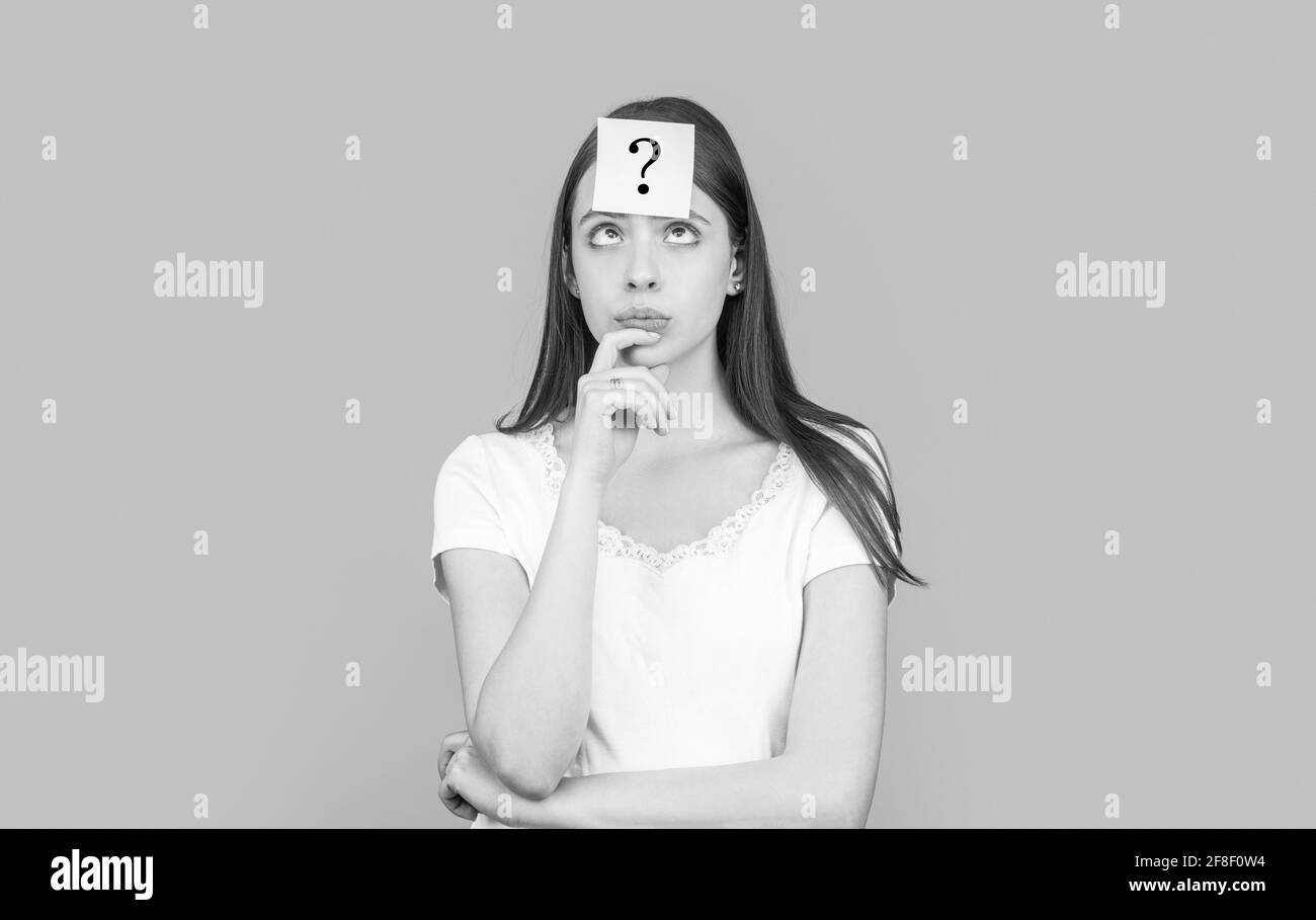 Confused female thinking with question mark on sticky note on forehead ...