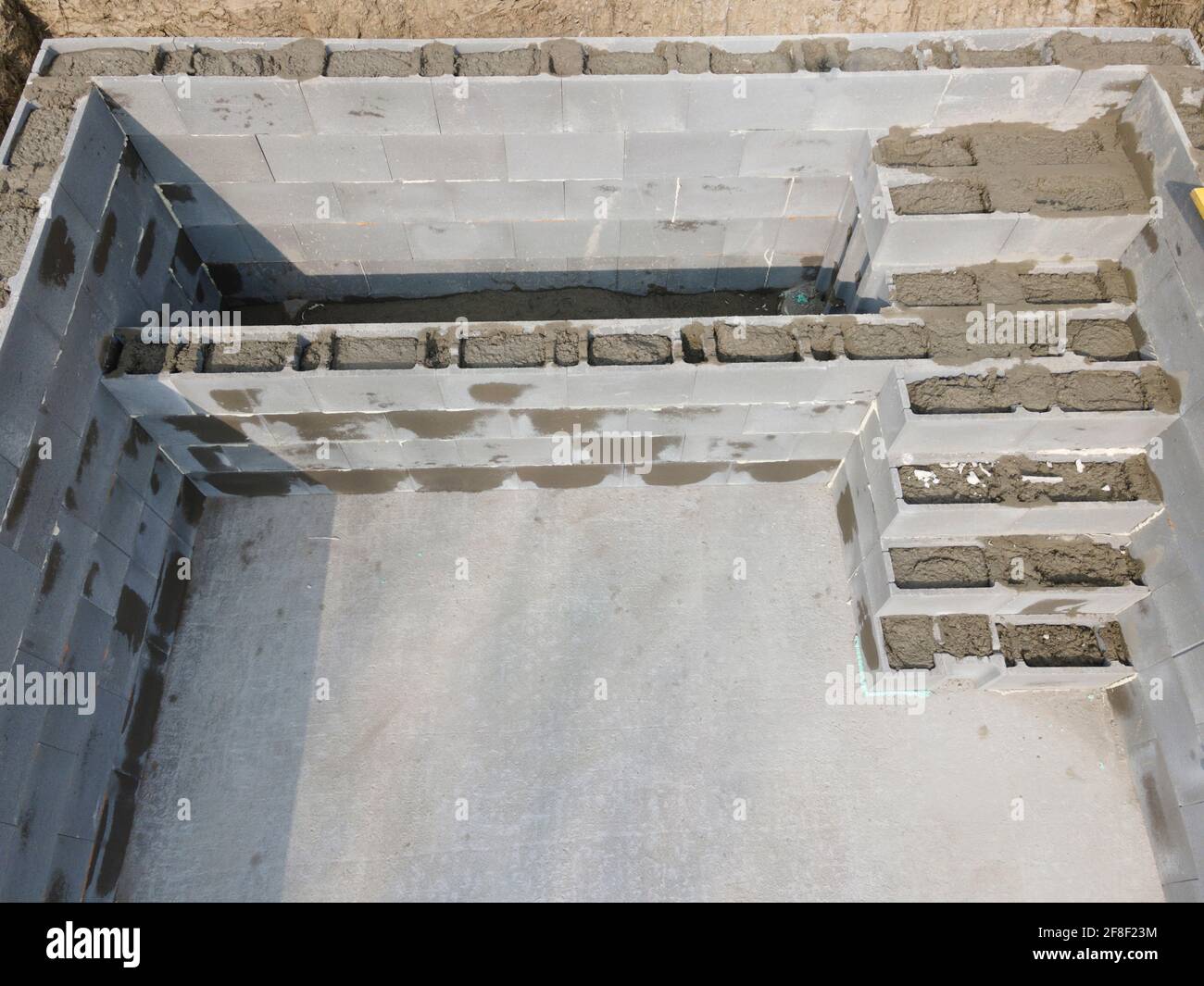 aerial drone shot of pool construction site, form blocks being filled ...