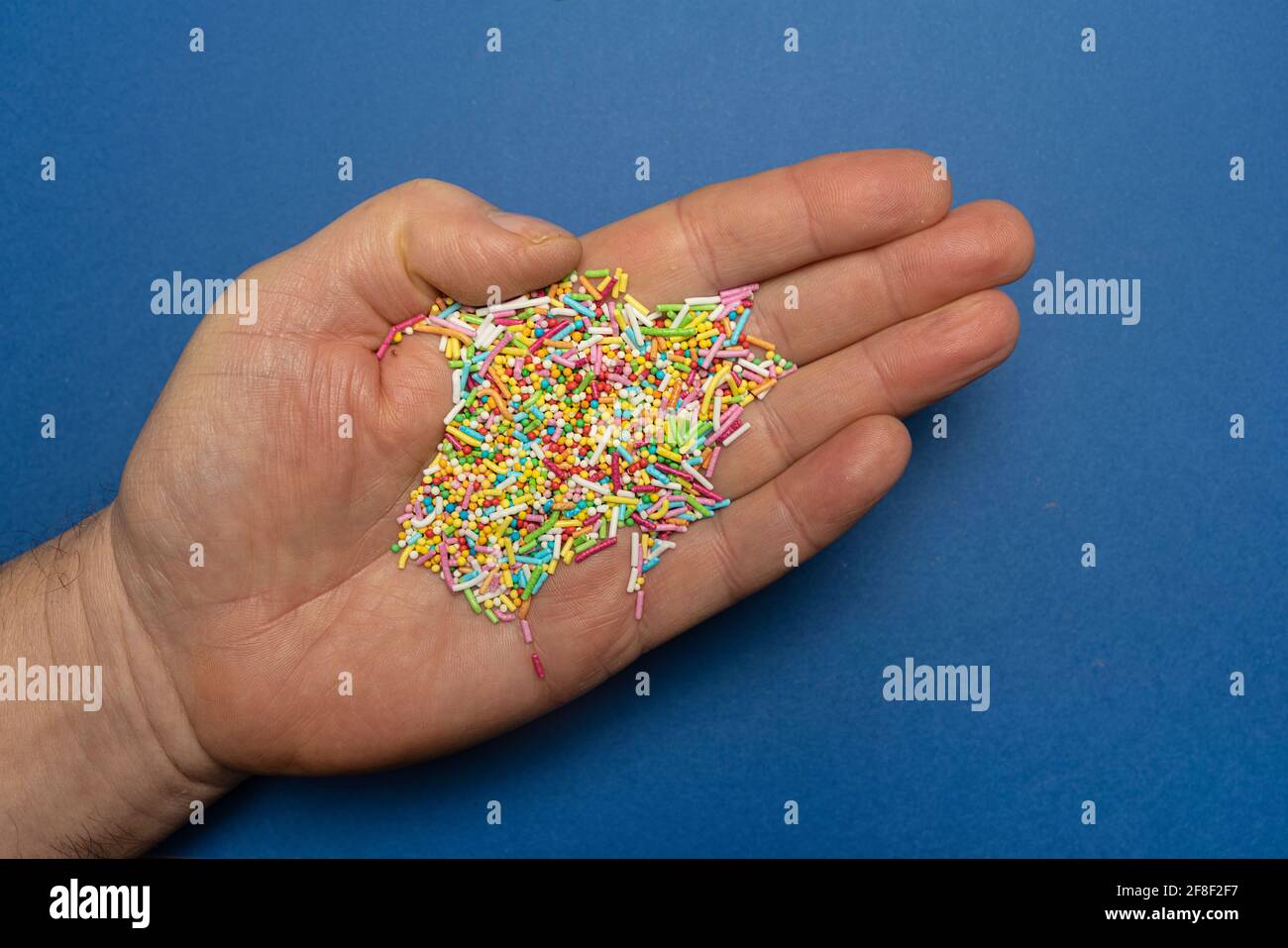 Colored sugar sprinkles in the palm of the hand Stock Photo - Alamy