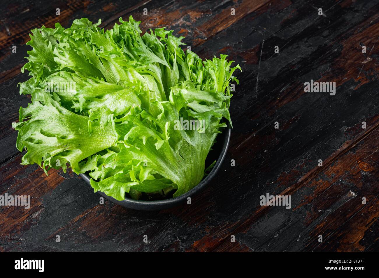 Fresh organic green batavia lettuce leaves, on old dark wooden table ...