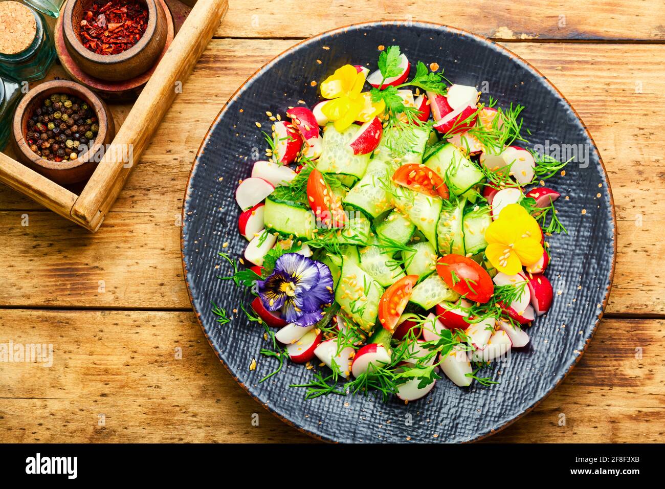 Cucumber,tomato,radish and greens salad decorated with edible flowers ...