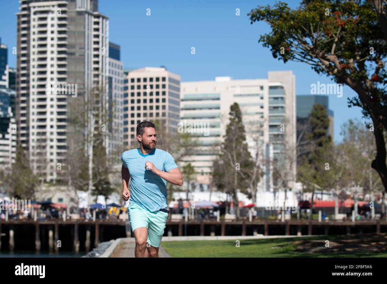 Full length of healthy man running and sprinting outdoors. Male runner ...