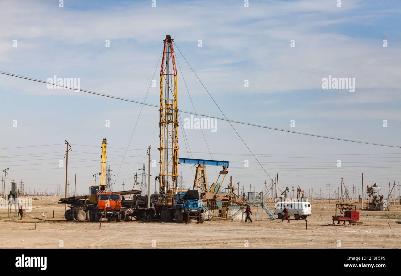 Works on oil drill rig. Workers, auto, trucks and pumping jack in ...