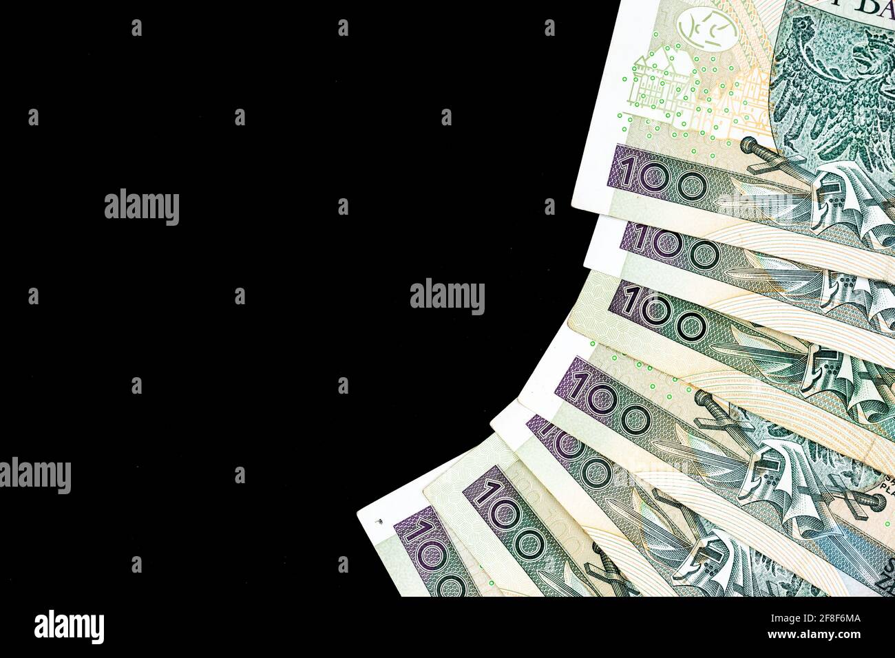 Polish banknotes of PLN 100 on a black background. Photo taken under ...