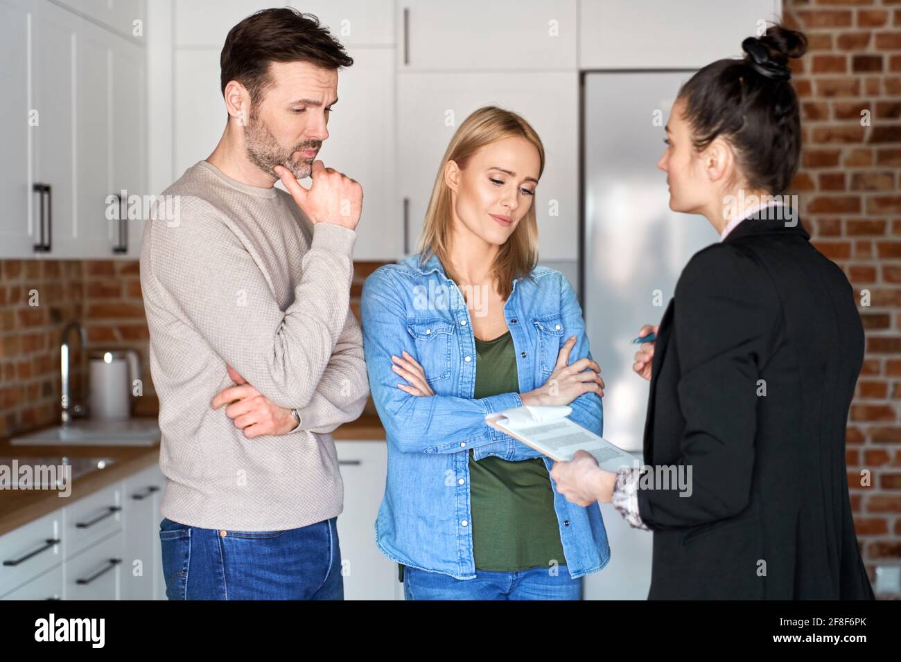 Sad couple during a meeting with a real estate agent Stock Photo - Alamy