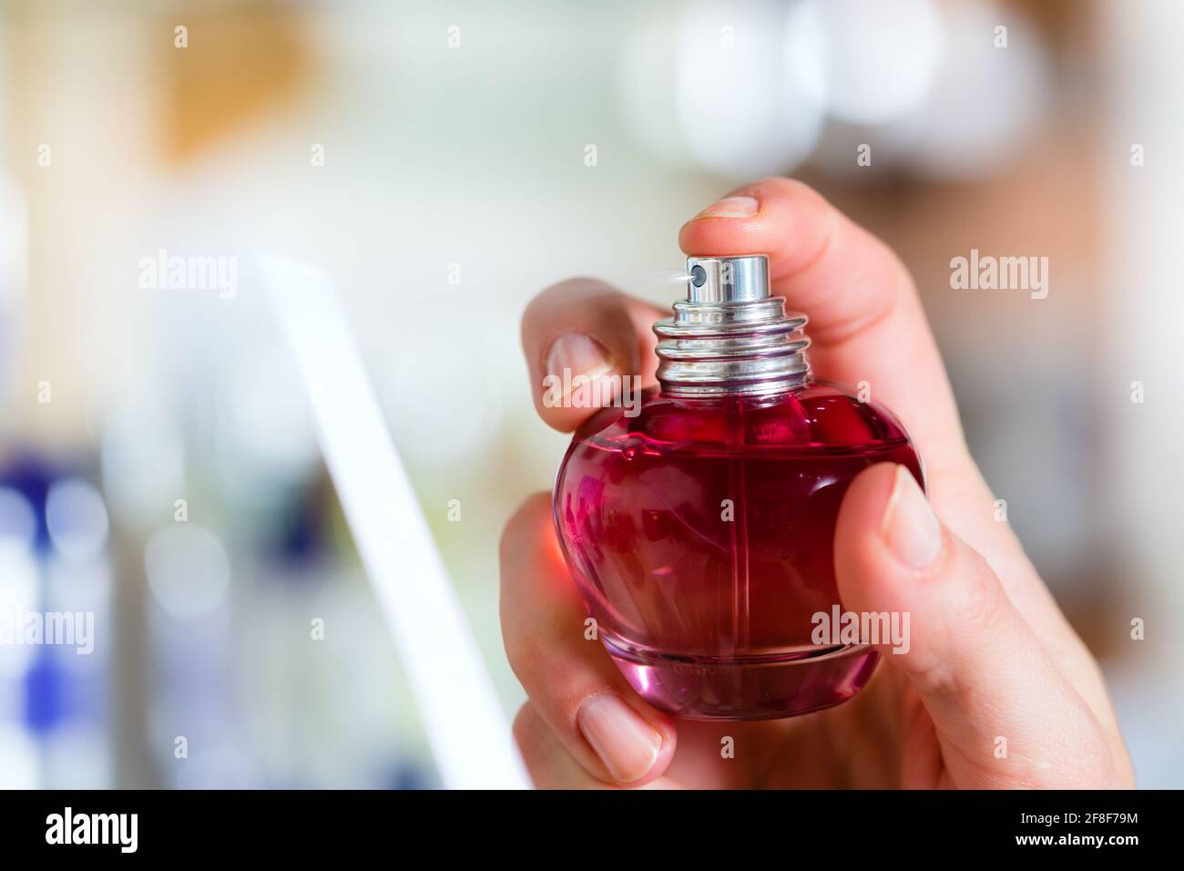 Young woman (only hands to be seen) buying perfume in a shop or store ...