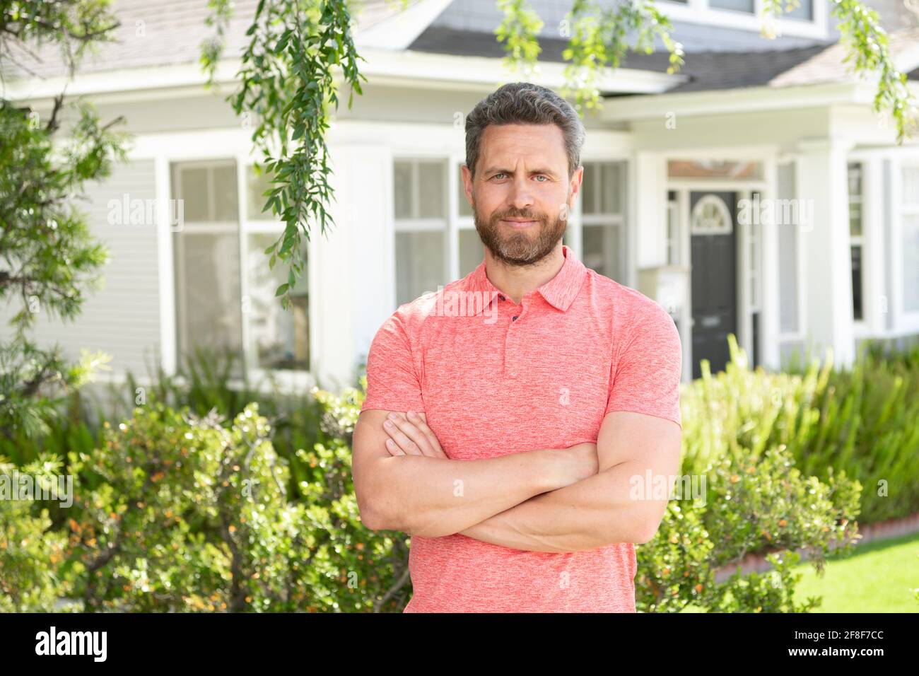 Portrait of confident real estate agent standing outside a house for ...