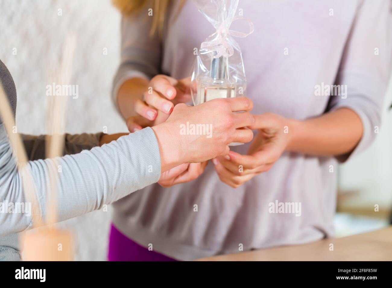 Close-up of woman's giving perfume gift to her friend Stock Photo - Alamy