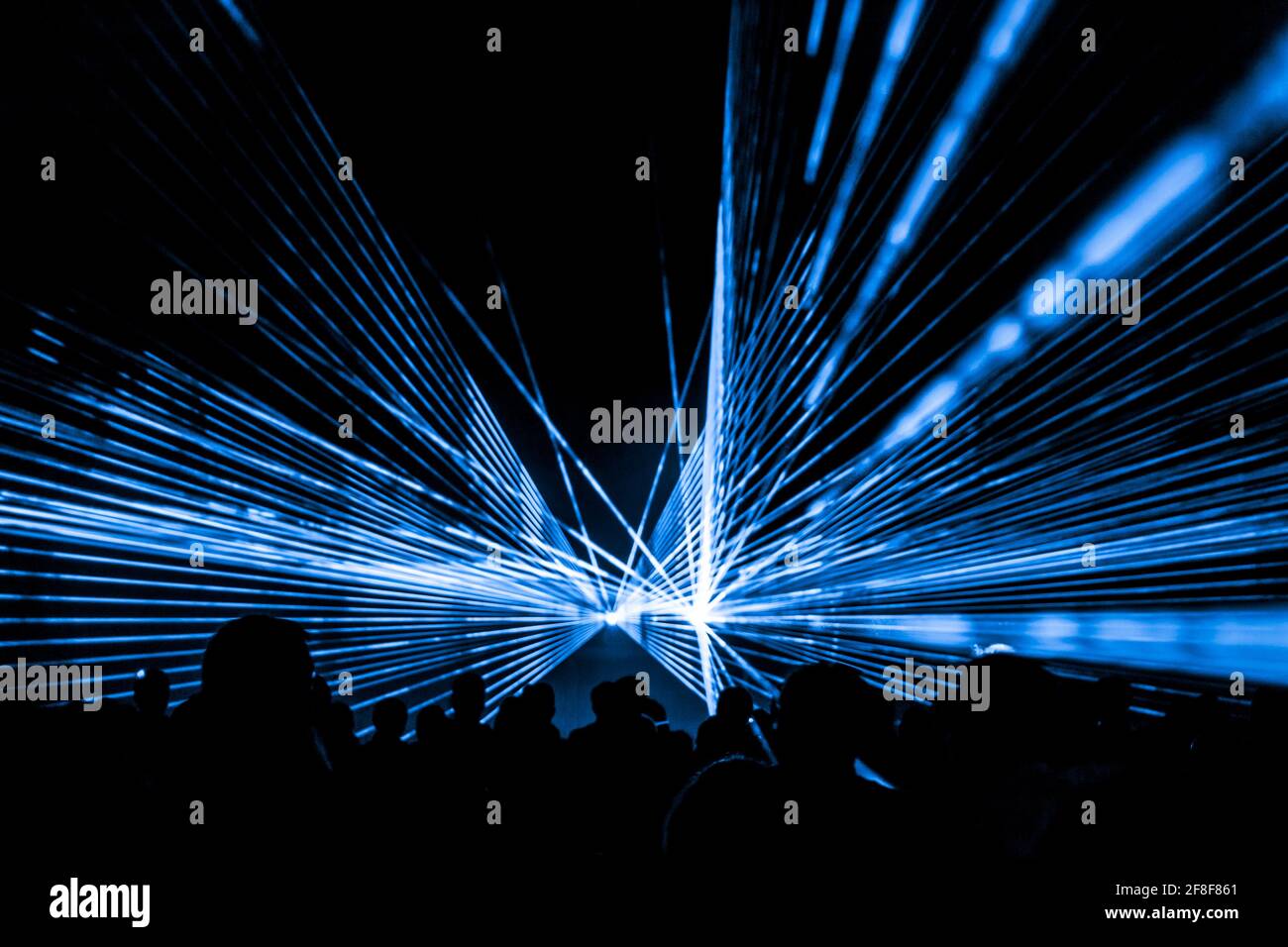 Blue laser show nightlife club stage with party people crowd. Luxury ...
