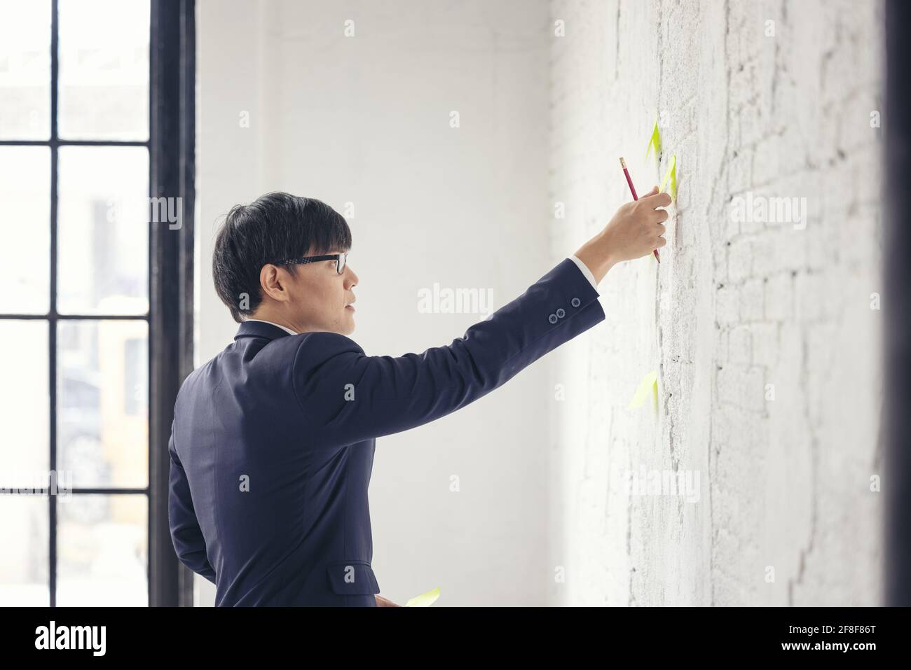 Portrait of businessmen post-it wall brick, Creative employee working ...
