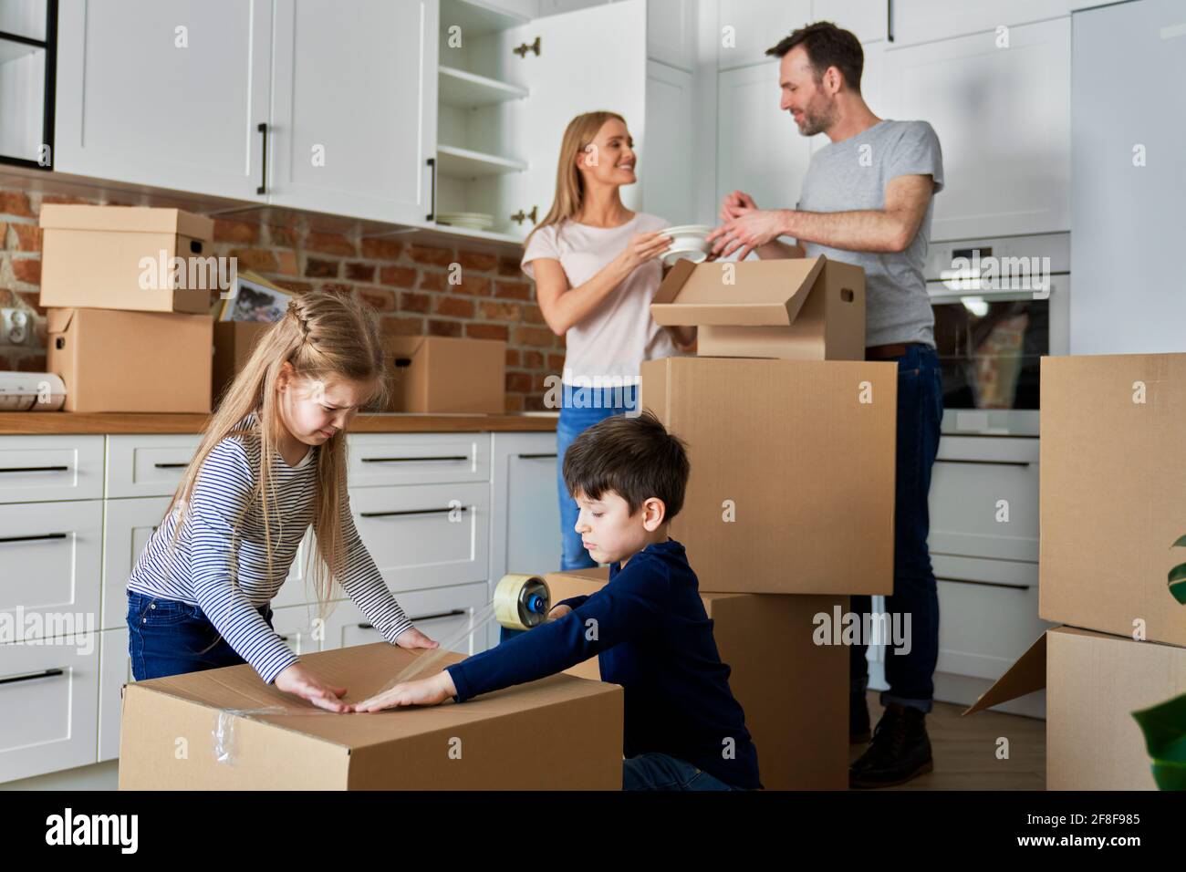 Family packing cardboard boxes for moving house Stock Photo - Alamy