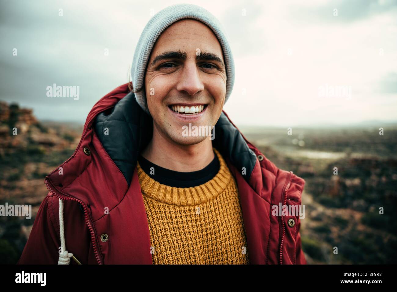 Smiling caucasian hiker walking through valley enjoying the outdoors ...