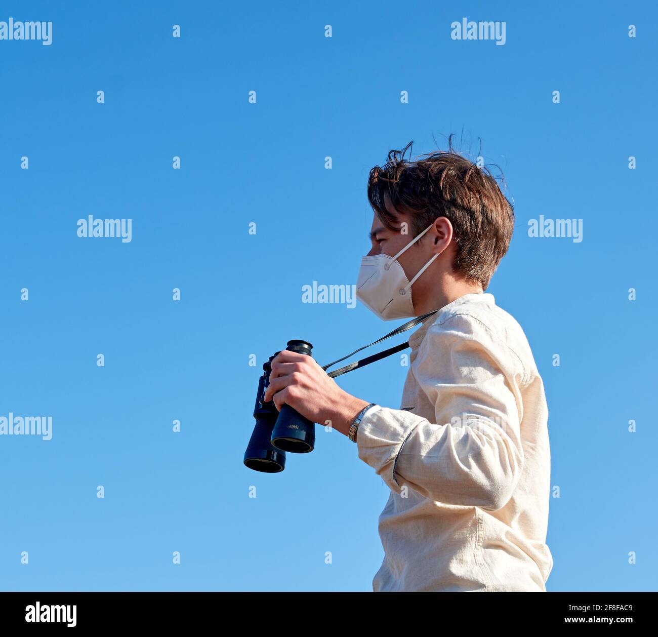 Spanish adventurous male traveler wearing a mask admiring the beautiful ...