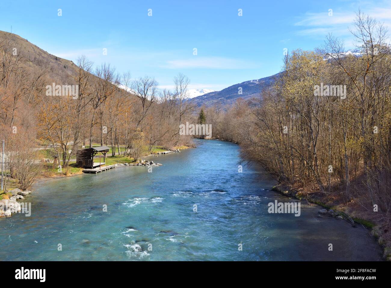 view on beautiful blue alpine river flowing between forest bank and ...