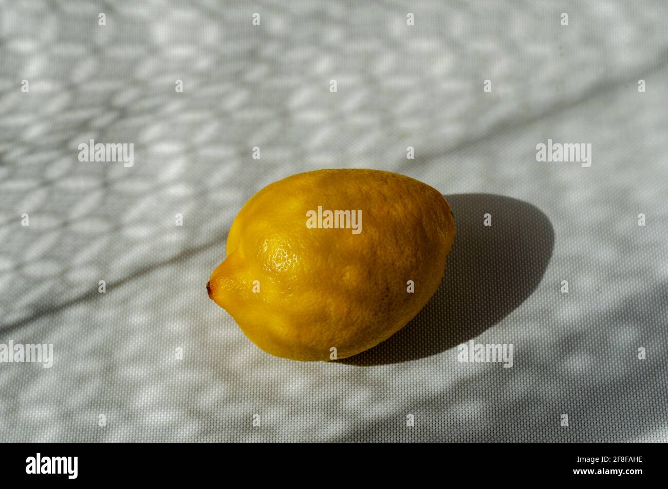Abstract minimalistic composition with yellow lemon in soft rays of ...