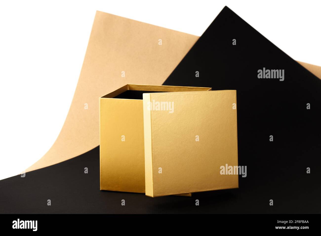 big open golden shining box on a background of beige, black, white ...
