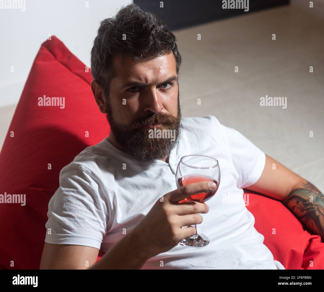 Drinking alone. Alcohol addiction. Serious man with glass of wine ...