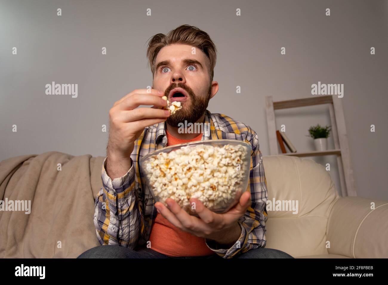 Single man on the couch watching TV Stock Photo - Alamy