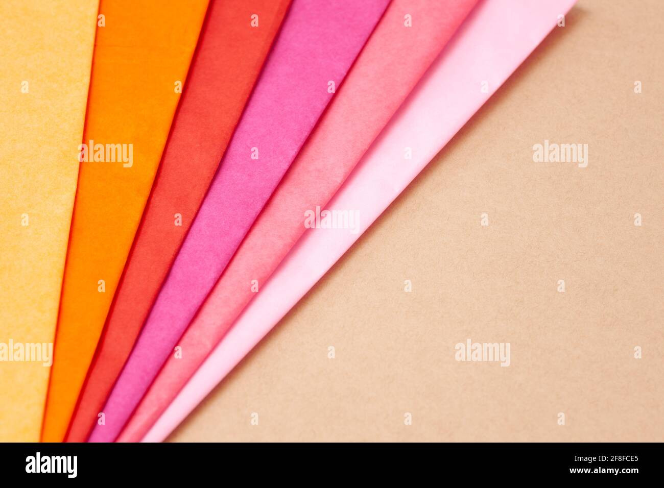 a stack of multi colored tissue paper spread out in a fan on a ...