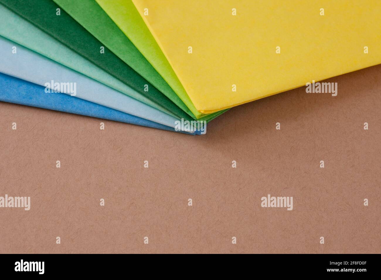 a stack of multi colored tissue paper spread out in a fan on a ...