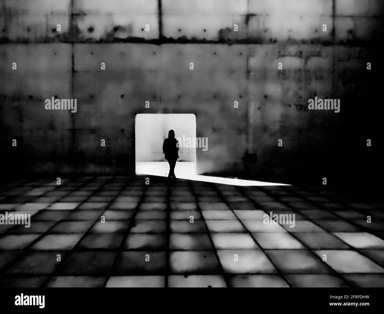 Silhouette of a woman exiting through a door in the wall Stock Photo ...