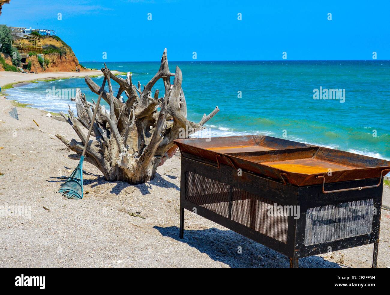 Old rusty grill for grilling meats, next to old tree stump driftwood on ...
