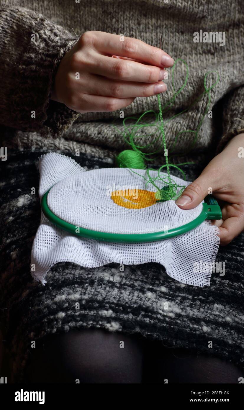 Embroidery in woman hands, female in knitted woolen grandma clothes ...