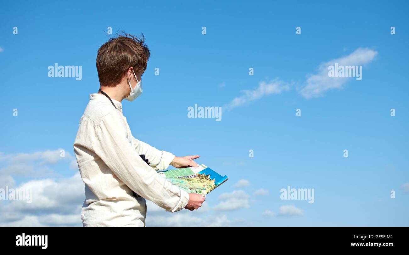 Side view of a young explorer pointing out the mountains oriented by a ...