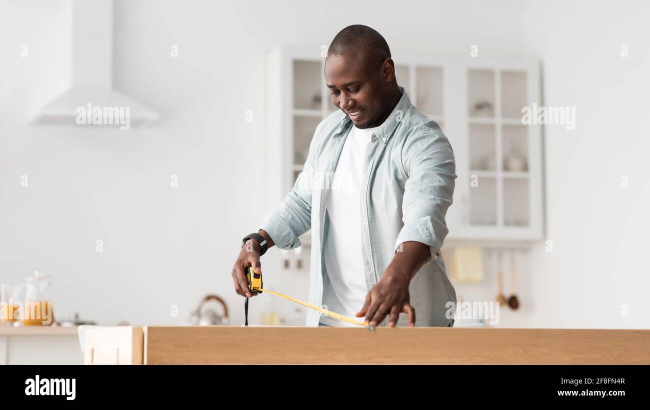 African american man assembly wooden furniture at home by yourself ...