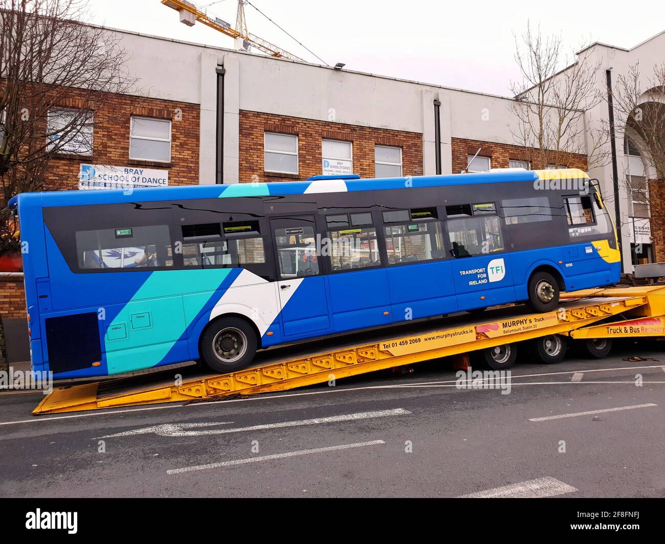 BRAY, IRELAND - Mar 15, 2021: Side view of broken bus on a flatbed tow ...