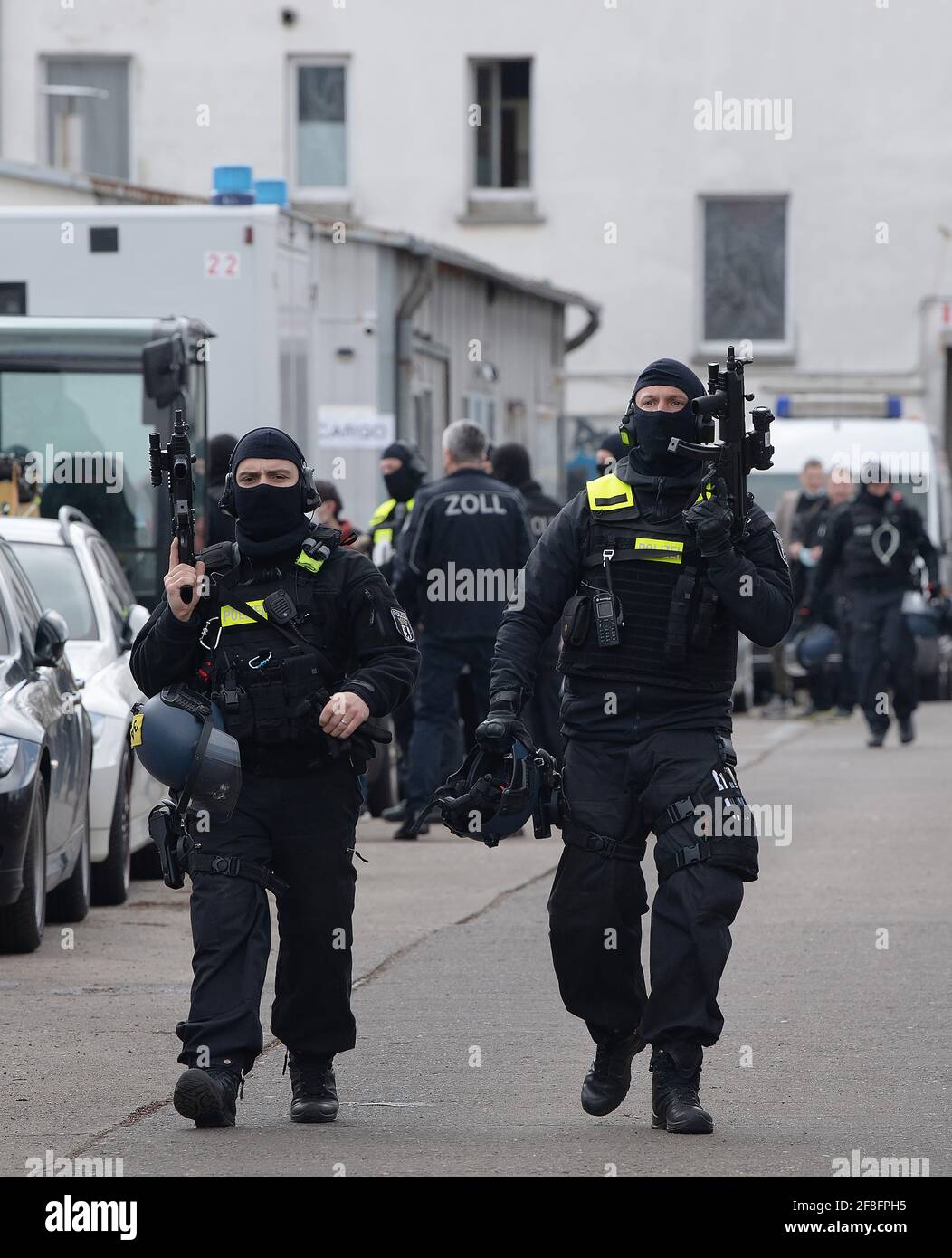 Berlin, Germany. 14th Apr, 2021. Police officers walk across a compound ...
