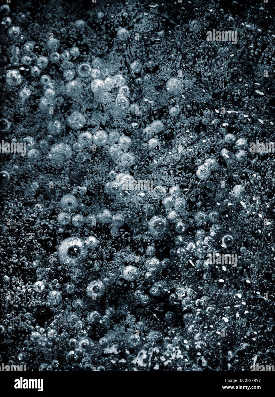 Bubbles trapped in ice. Blue toned black and white Stock Photo - Alamy