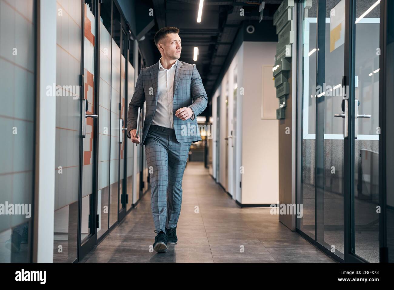 Stylish young man walking down the hallway Stock Photo - Alamy