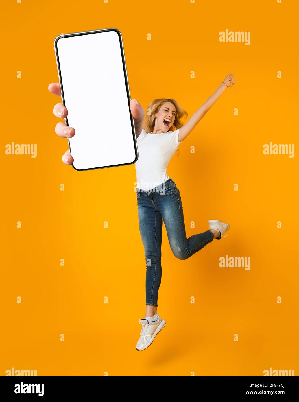 Emotional blonde woman jumping and shouting, going crazy, showing ...