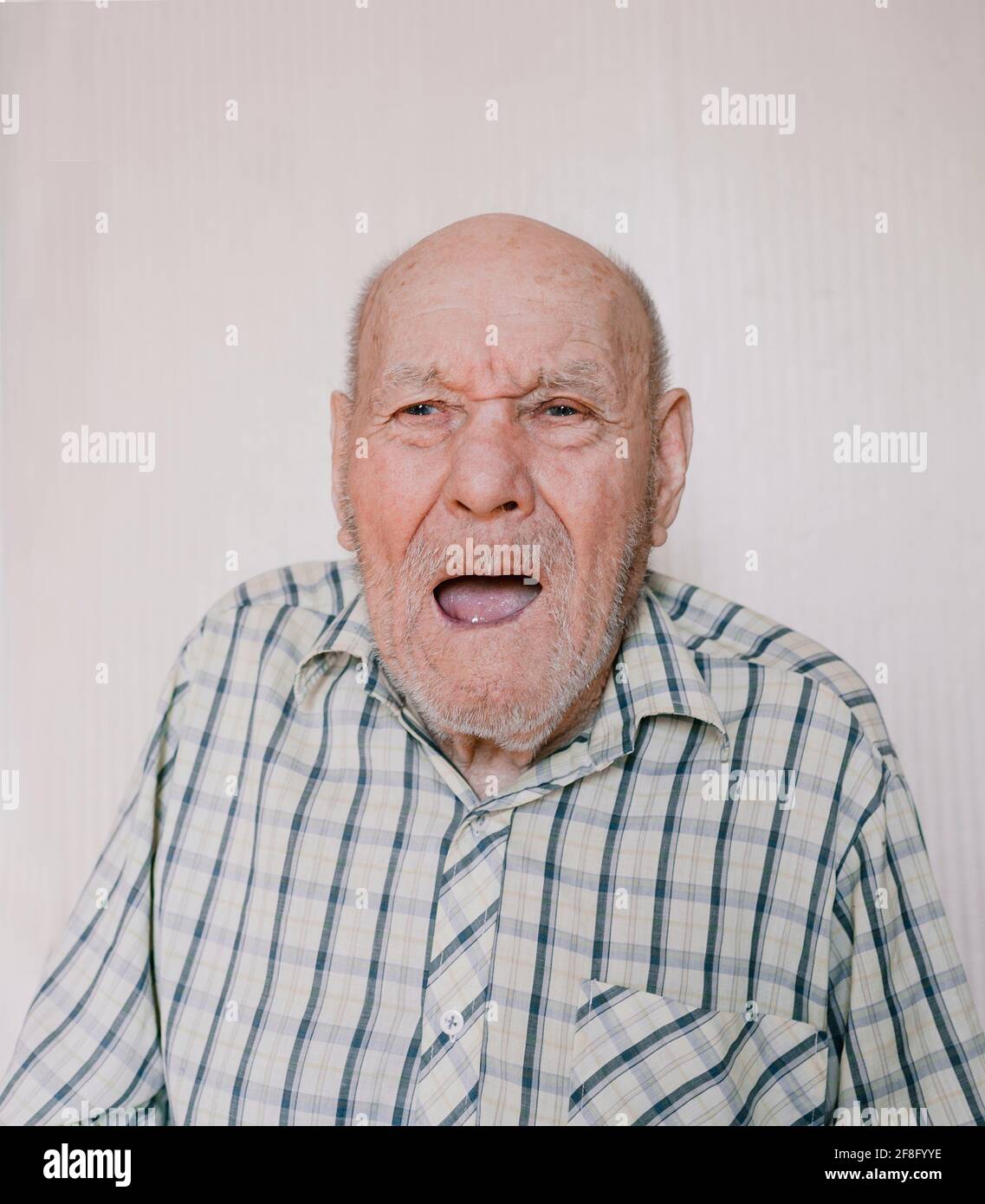 a large portrait of an old man on a light background with deep wrinkles ...