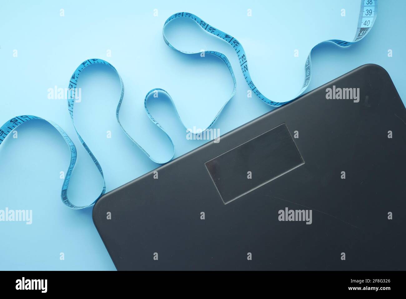 a tape measure and Bathroom scale on blue background Stock Photo - Alamy