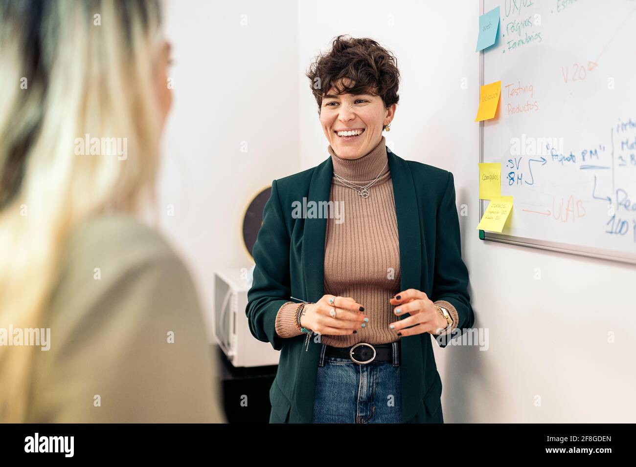 Happy business woman talking with her coworker during work reunion ...