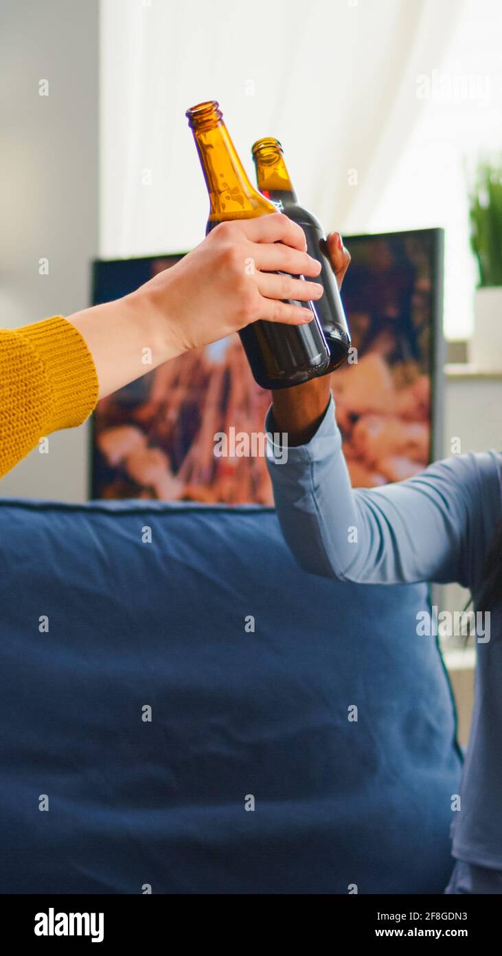 Multiracial group of friends with masks enjoying a beer during new ...