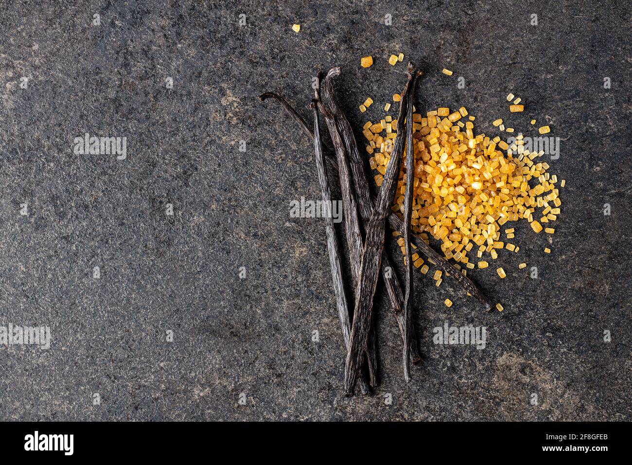Vanilla pods. Sticks of vanilla with brown sugar on black table. Top ...