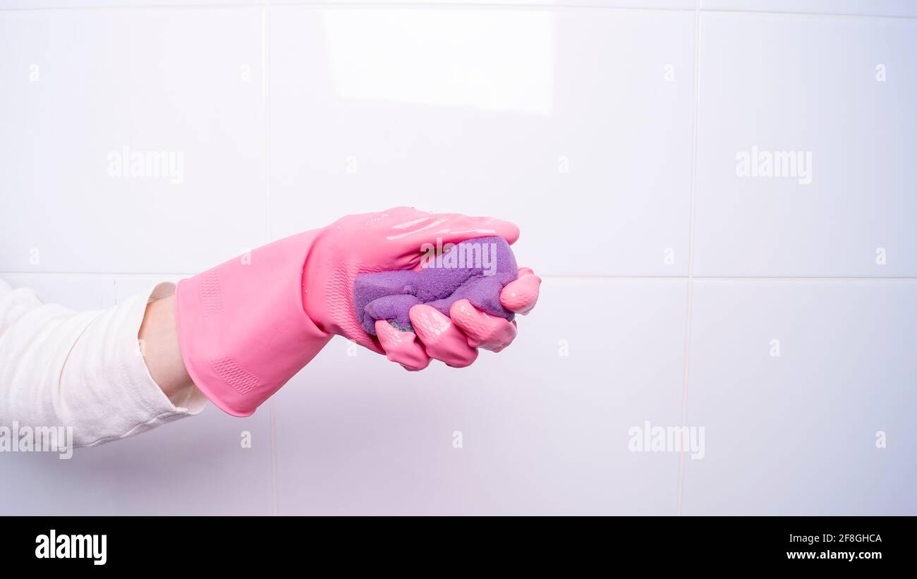 female hand in a rubber glove holding a rag for cleaning surfaces Stock ...
