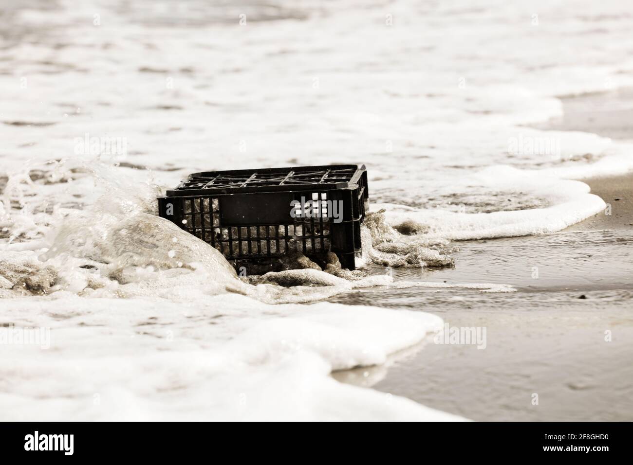 black plastic box thrown on the shore, environmental pollution Stock ...