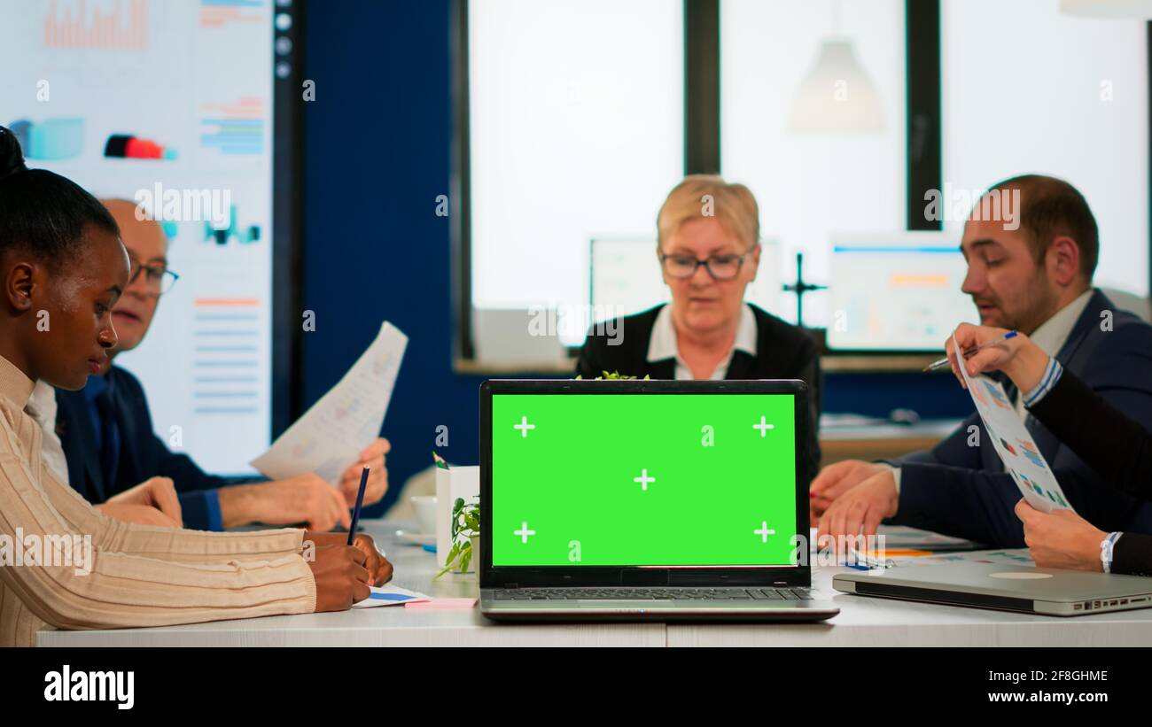 Group of business people discussing company plan with mockup laptop in ...