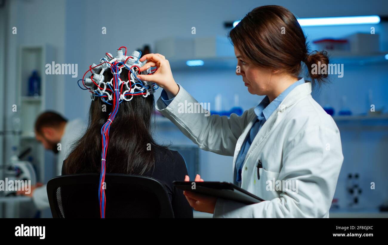 Woman patient wearing performant eeg headset scanning brain electrical ...