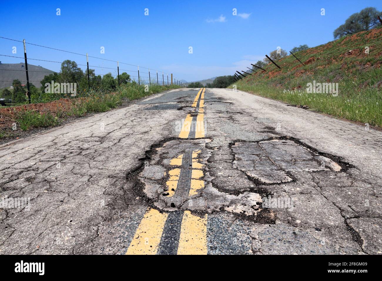 Pothole road - damaged rural road surface in California, USA Stock ...