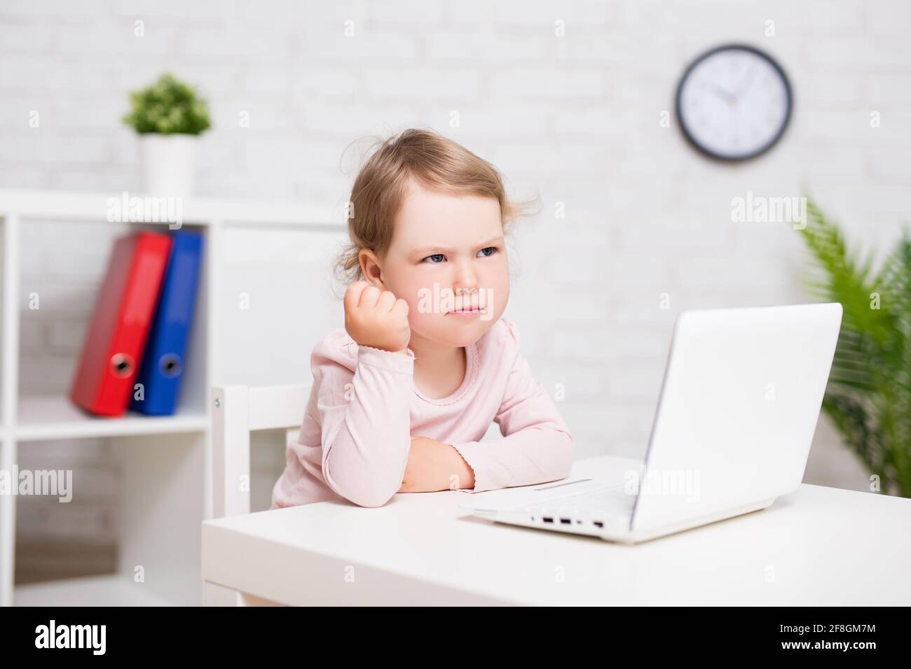 childhood, education and technology concept - sad or angry little girl ...